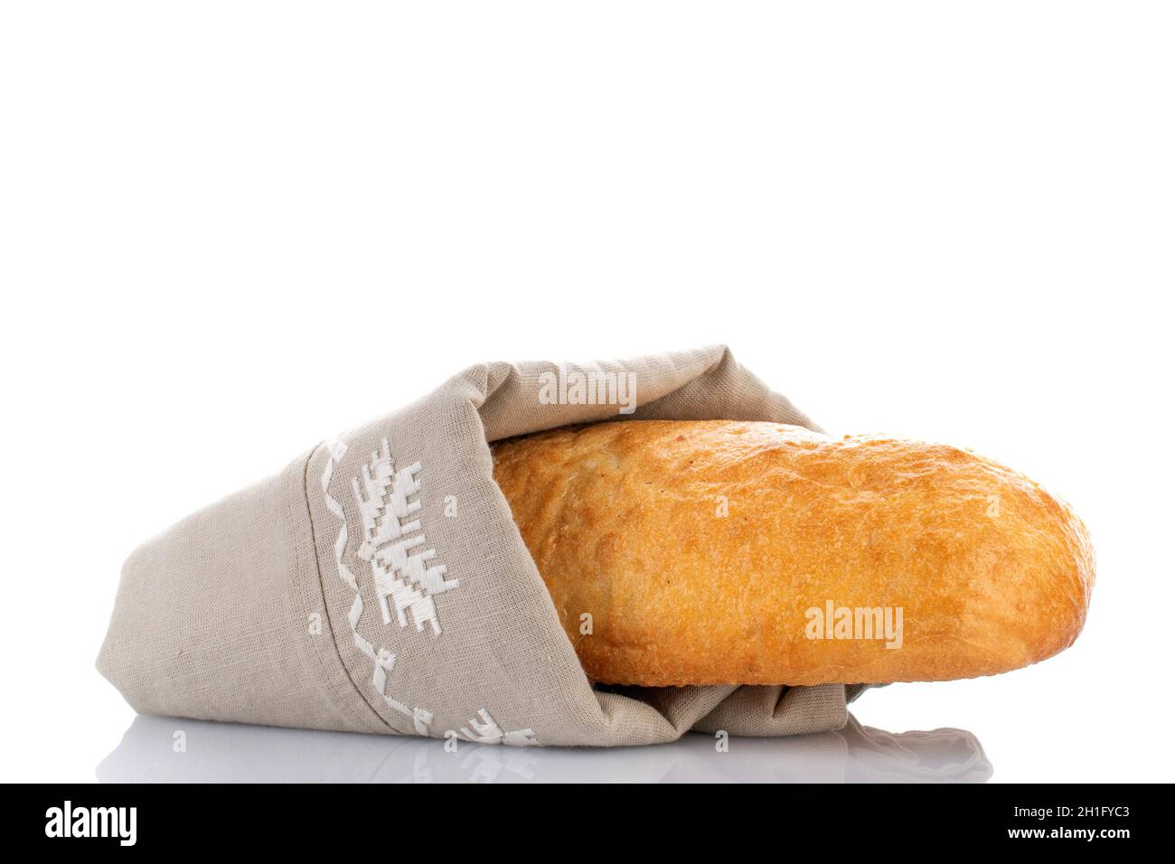 One fragrant ciabatta with a linen napkin, close-up, isolated on white ...