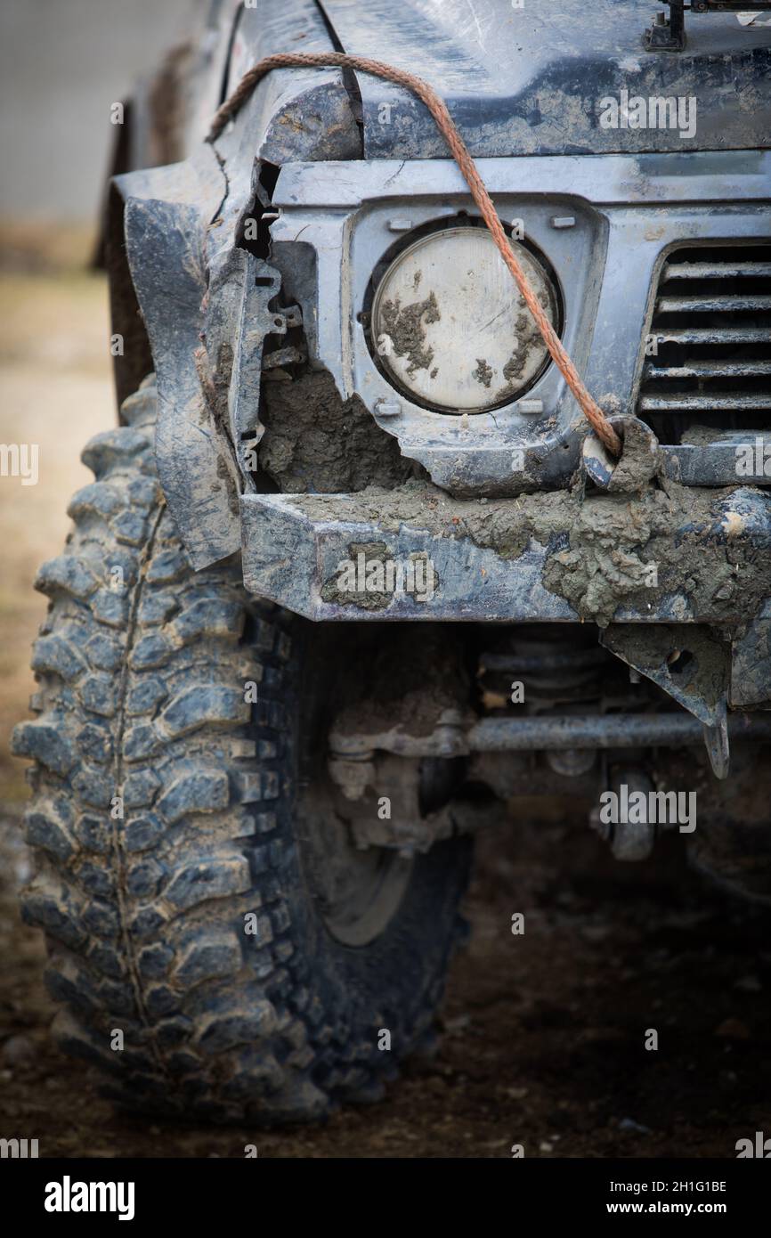 Dirty off road car, with close up on is wheel, headlight and front ...