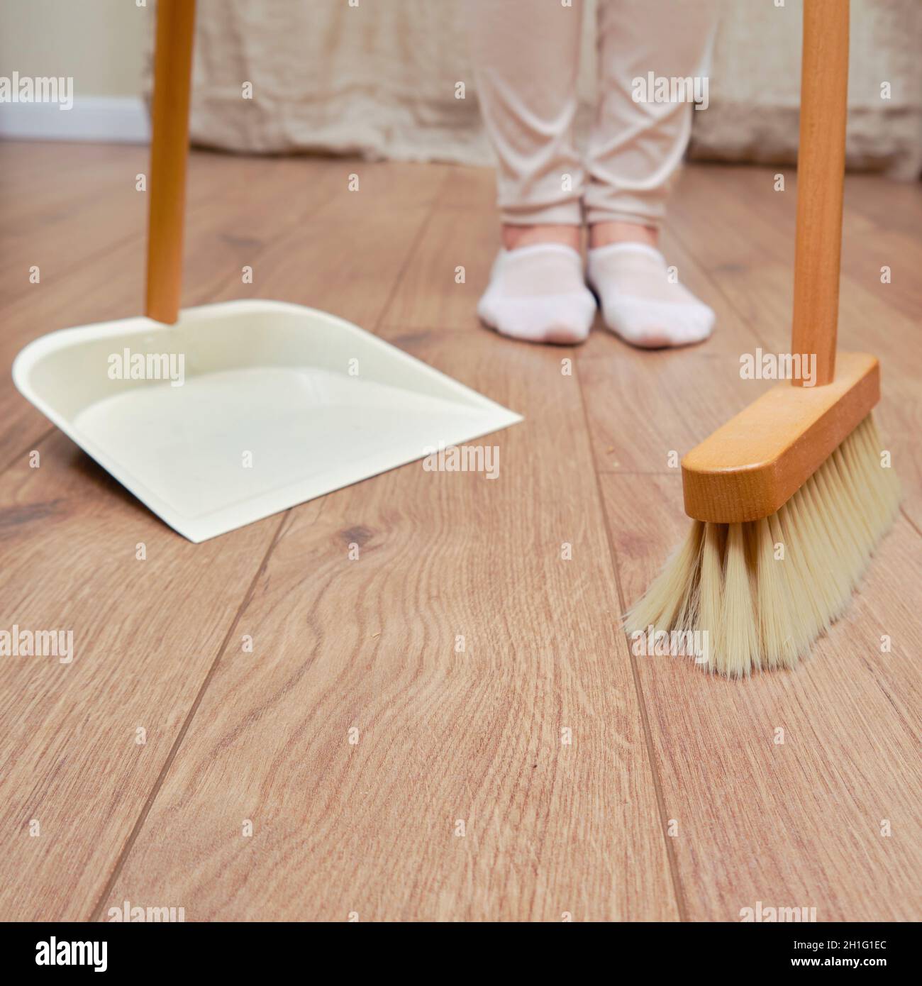 Woman sweeping floor with broom and dustpan while cleaning home living ...