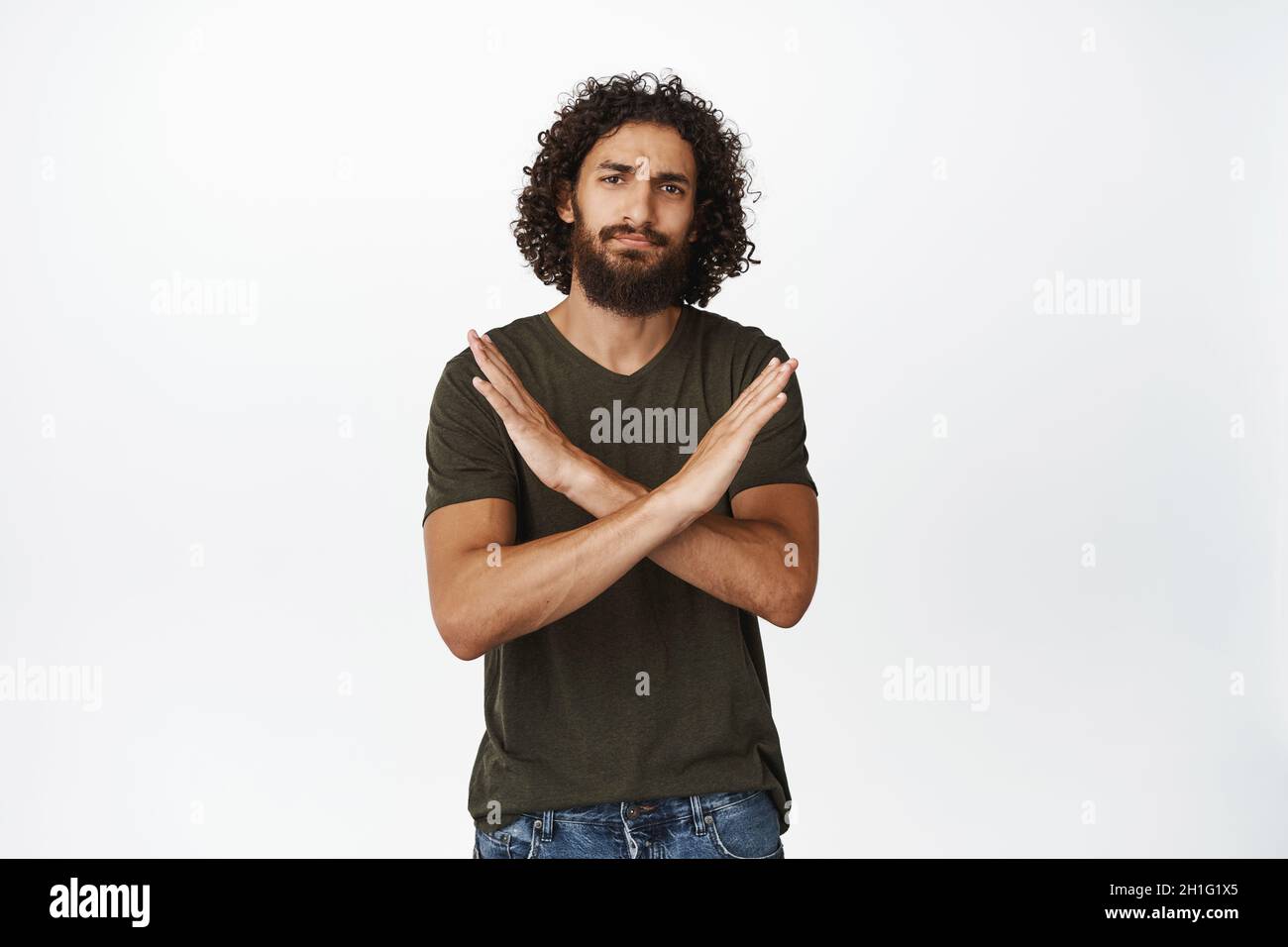 Disappointed young man making stop gesture, showing crossed arms sign ...