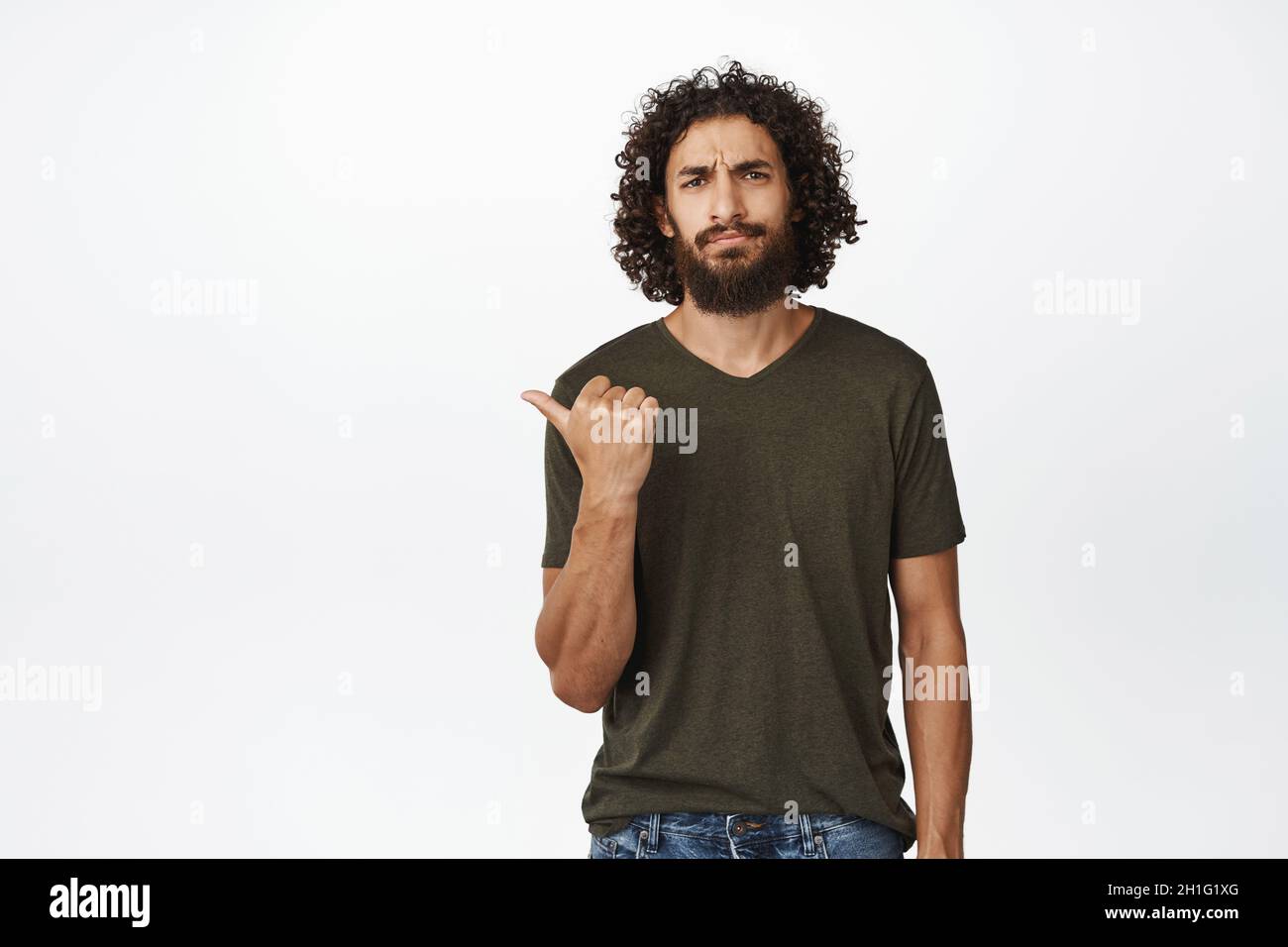 Sad and disappointed middle easter guy pointing finger left, showing ...