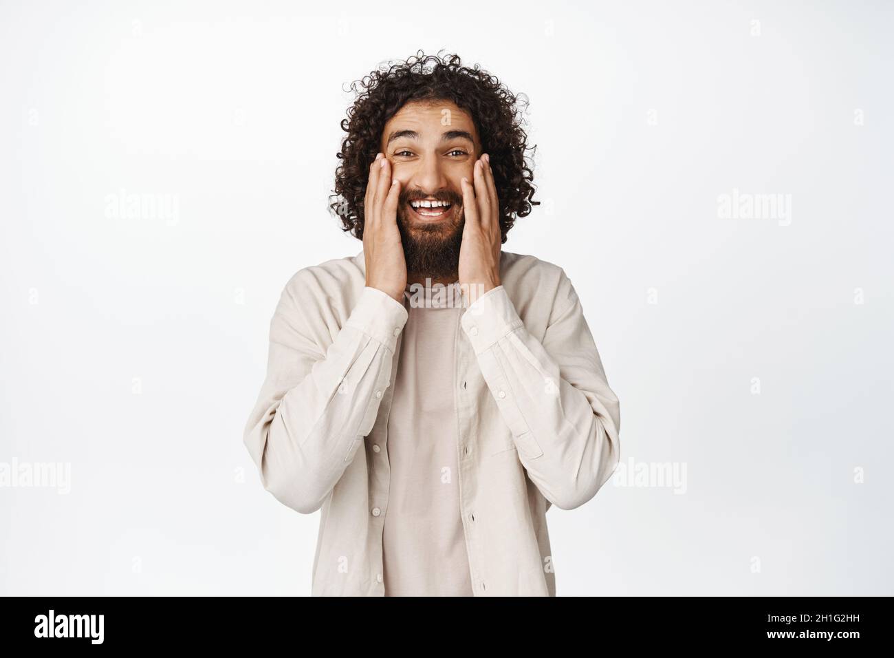 Image of smiling surprised man with curly hair, looking amazed and ...