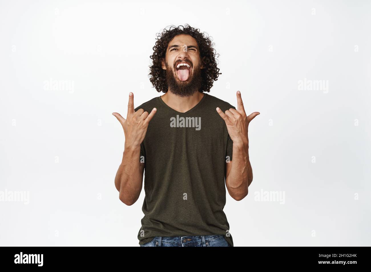 Carefree young guy, screaming with heavy metal horns gesture, enjoying ...