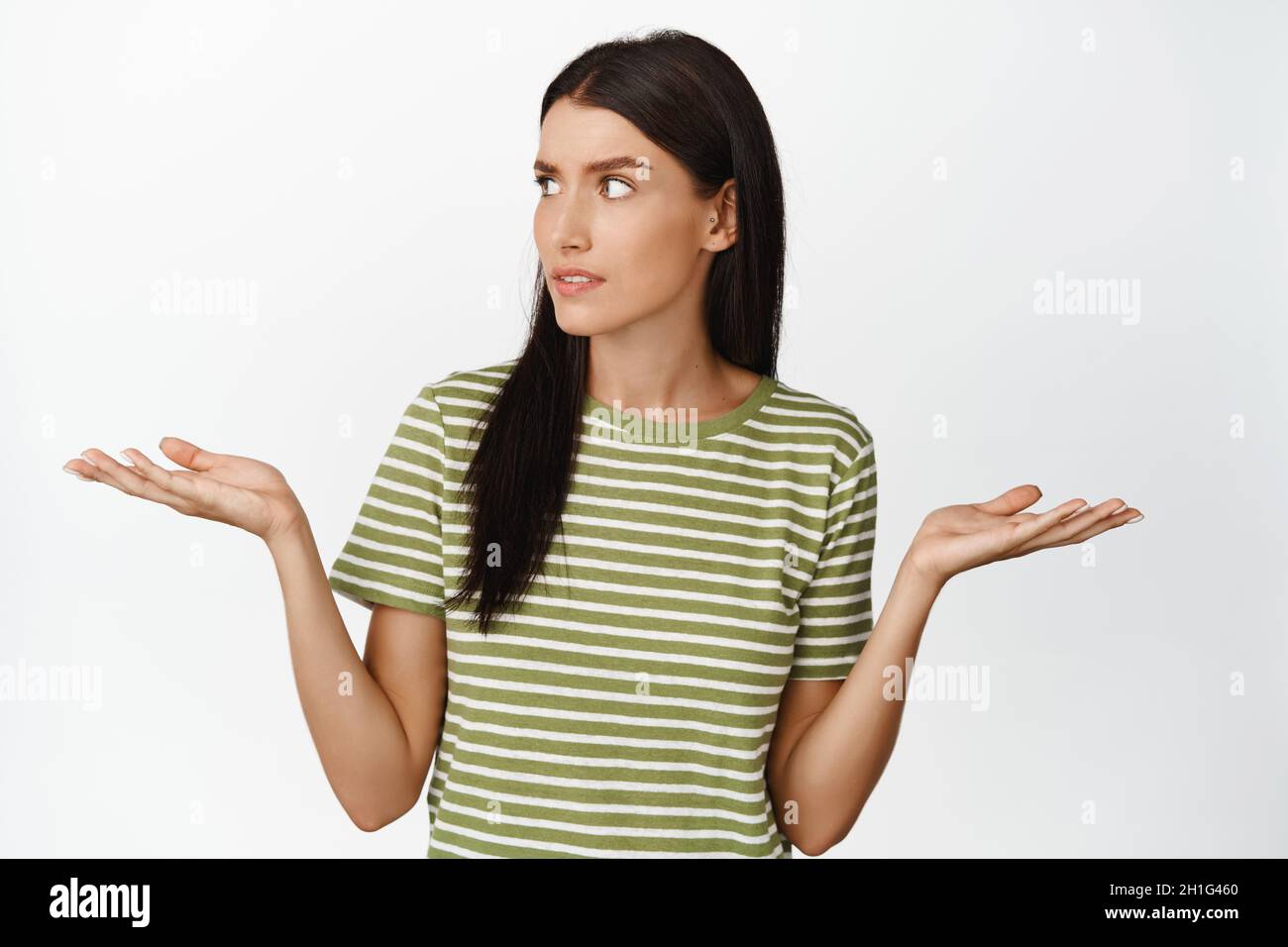 Confused woman looking upset and shrugging, staring at something ...