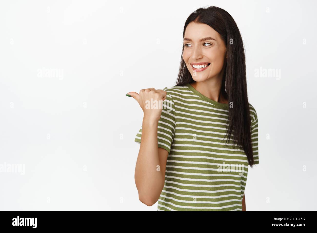 Smiling brunette woman pointing left, showing way, demonstrating sale ...