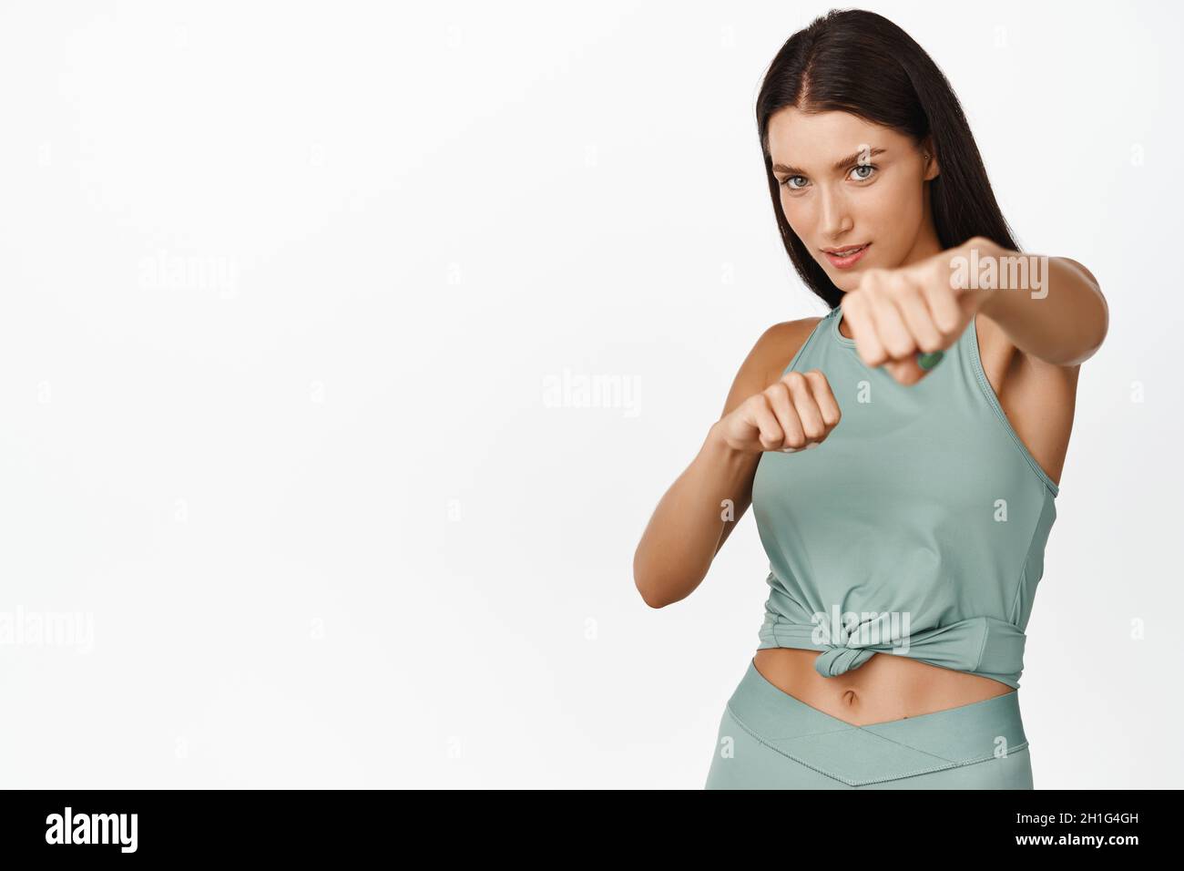Strong and confident female athlete practice punches, stretch out fist ...