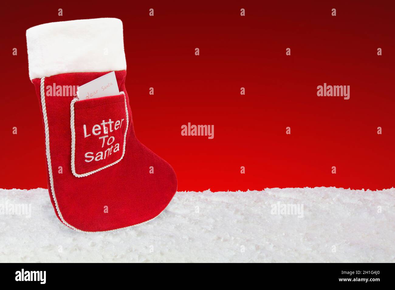 Red Christmas stocking with a letter to Santa in the front pocket Stock ...