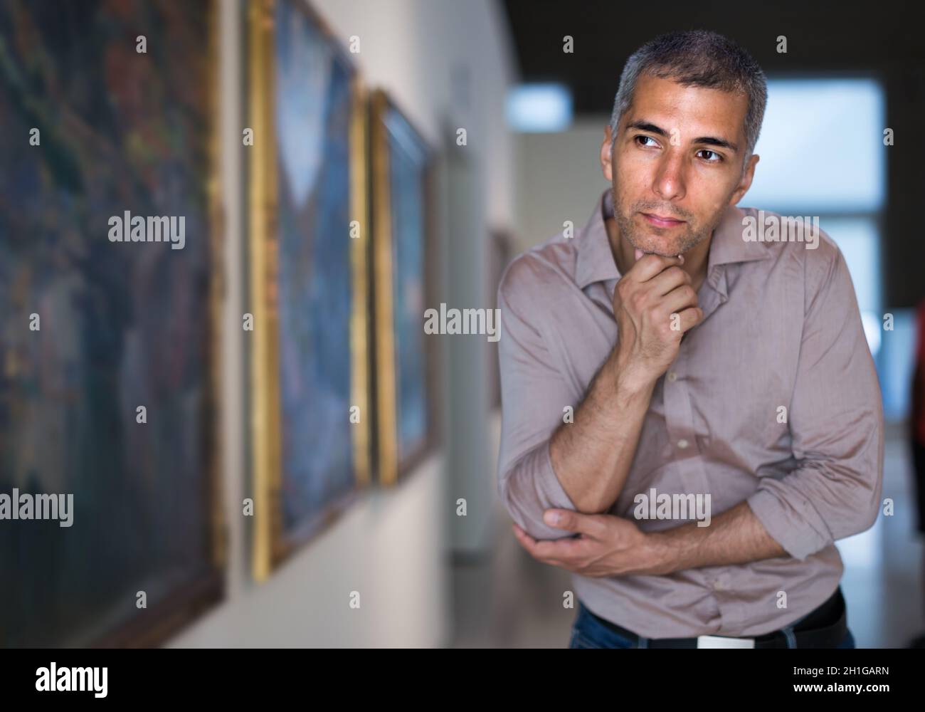 Adult man is visiting museum and looking at the pictures Stock Photo ...
