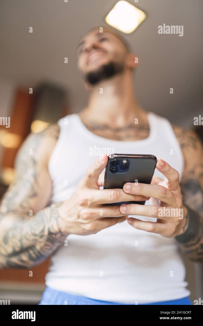 Vertical low angle shallow focus shot of a young man holding his phone ...
