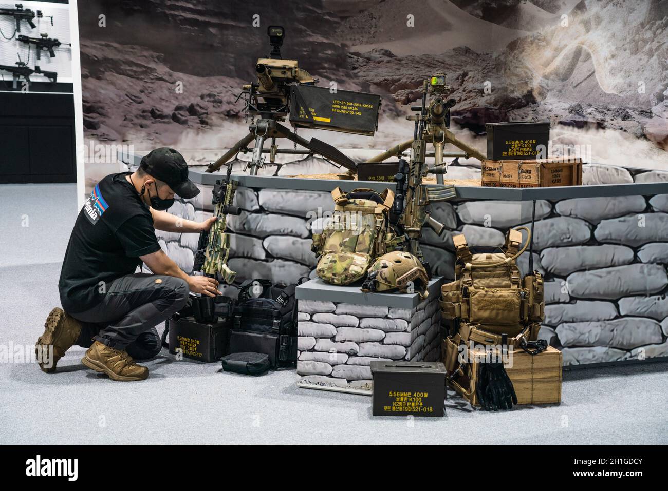 A staff member at the exhibition booth sets a gun for Seoul ...