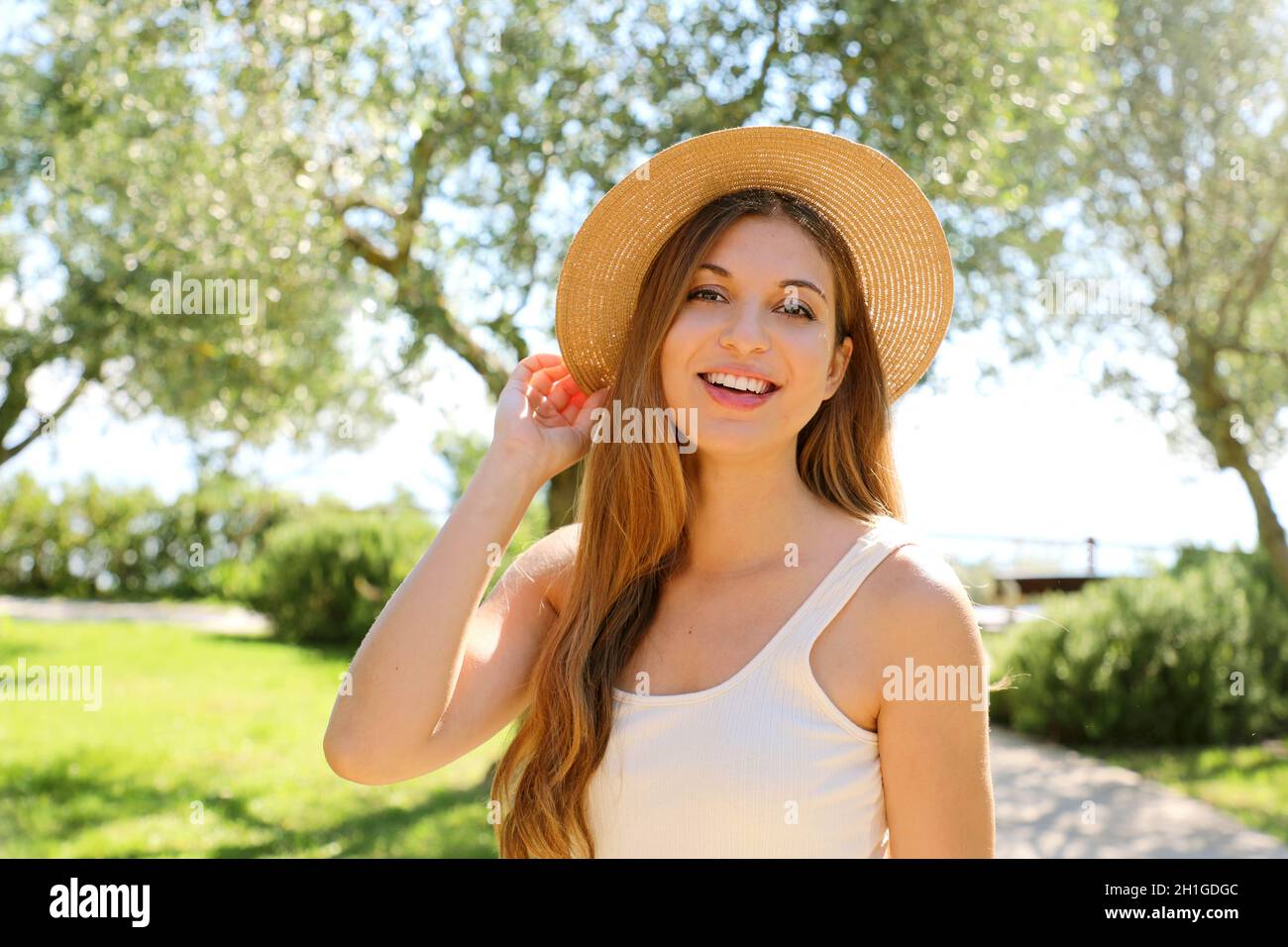 Portrait of a beautiful smiling girl enjoying olive garden in Sirmione ...