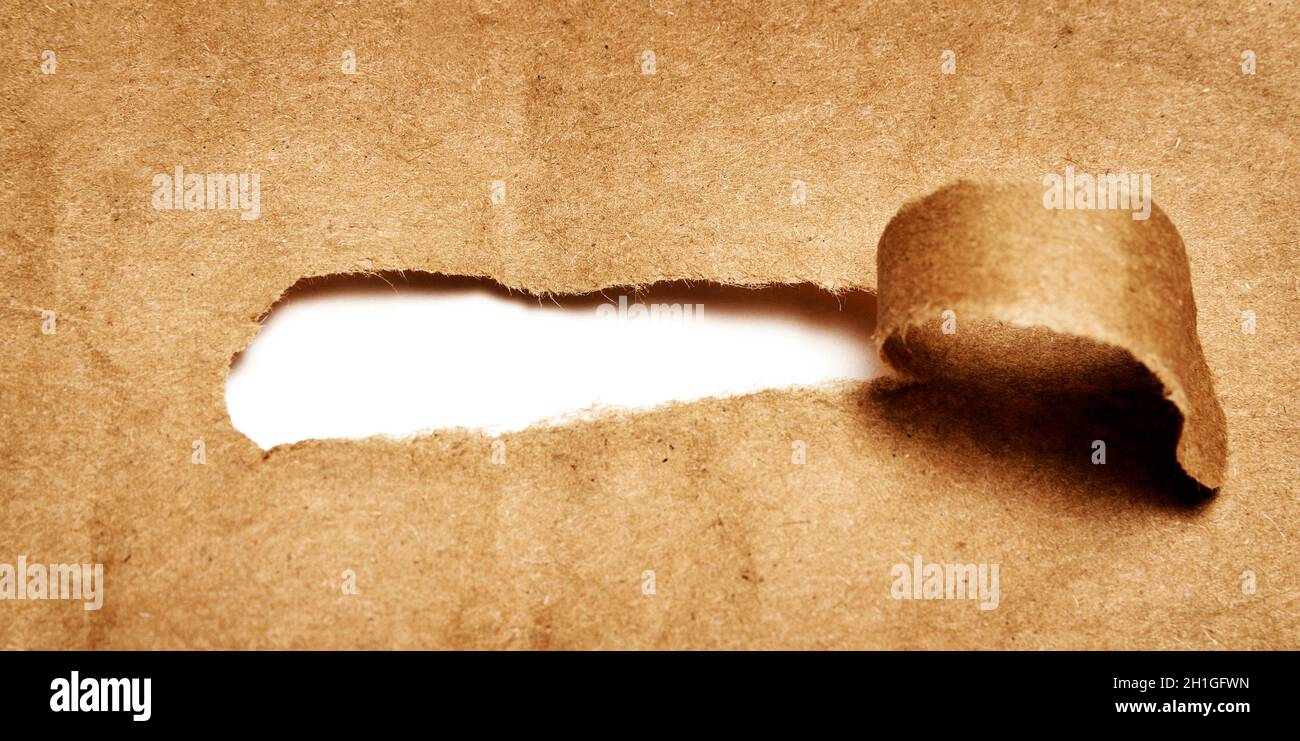 Closeup of torn brown paper with white background for text space Stock ...