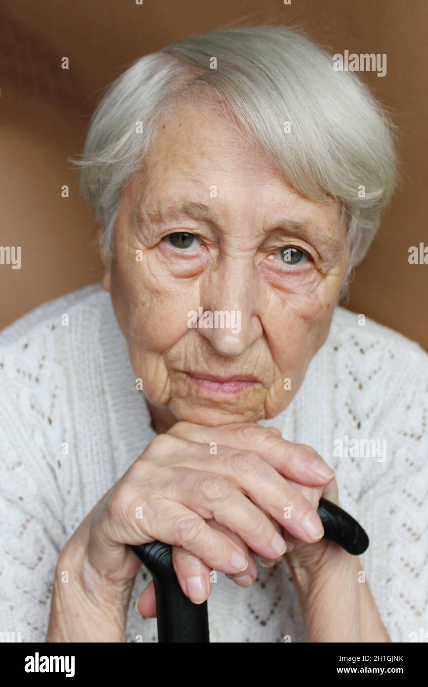 The face and eyes of an old sad woman. She sitting at home and looking ...