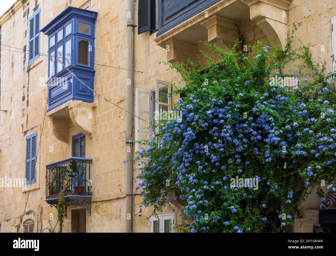 Residential house facade with traditional Maltese blue enclosed wooden ...
