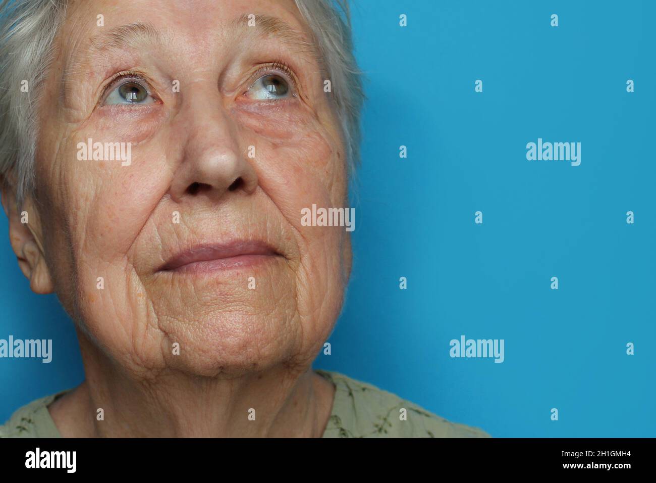 Smiling senior woman on blue. Hope and dreams concept Stock Photo - Alamy