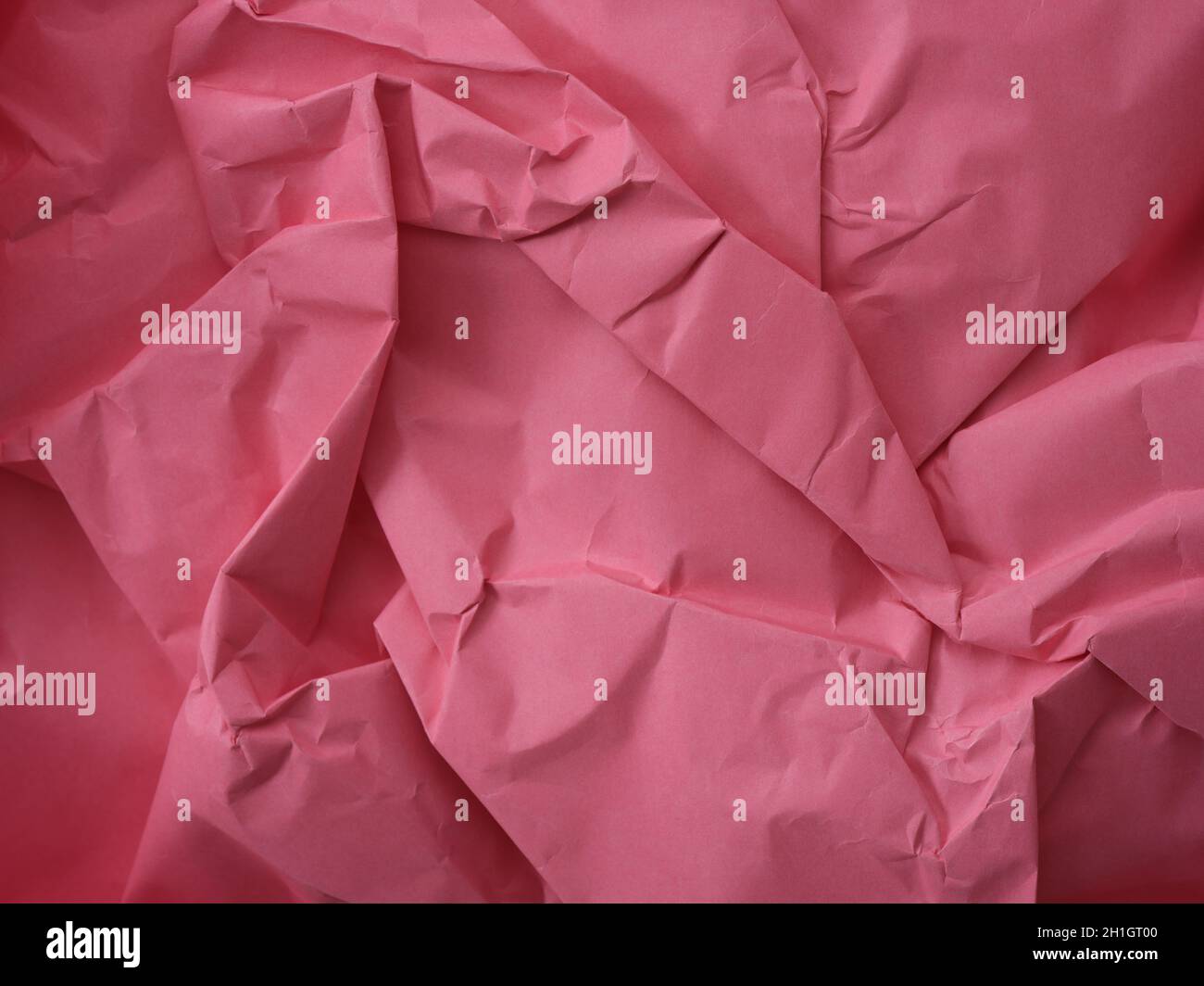 A crumpled pink paper background. Close up Stock Photo - Alamy