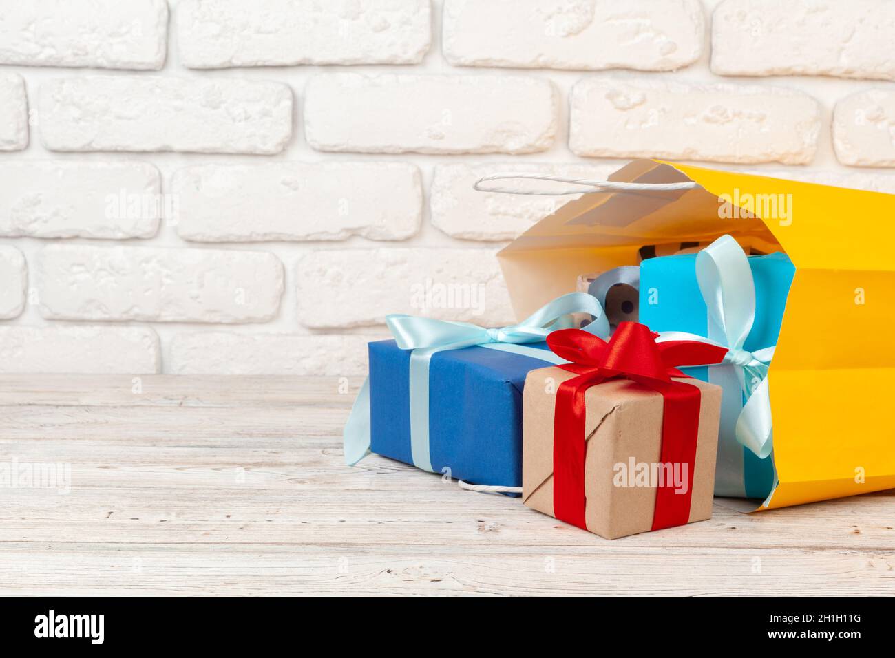 Decorated gift box put against white brick wall Stock Photo - Alamy