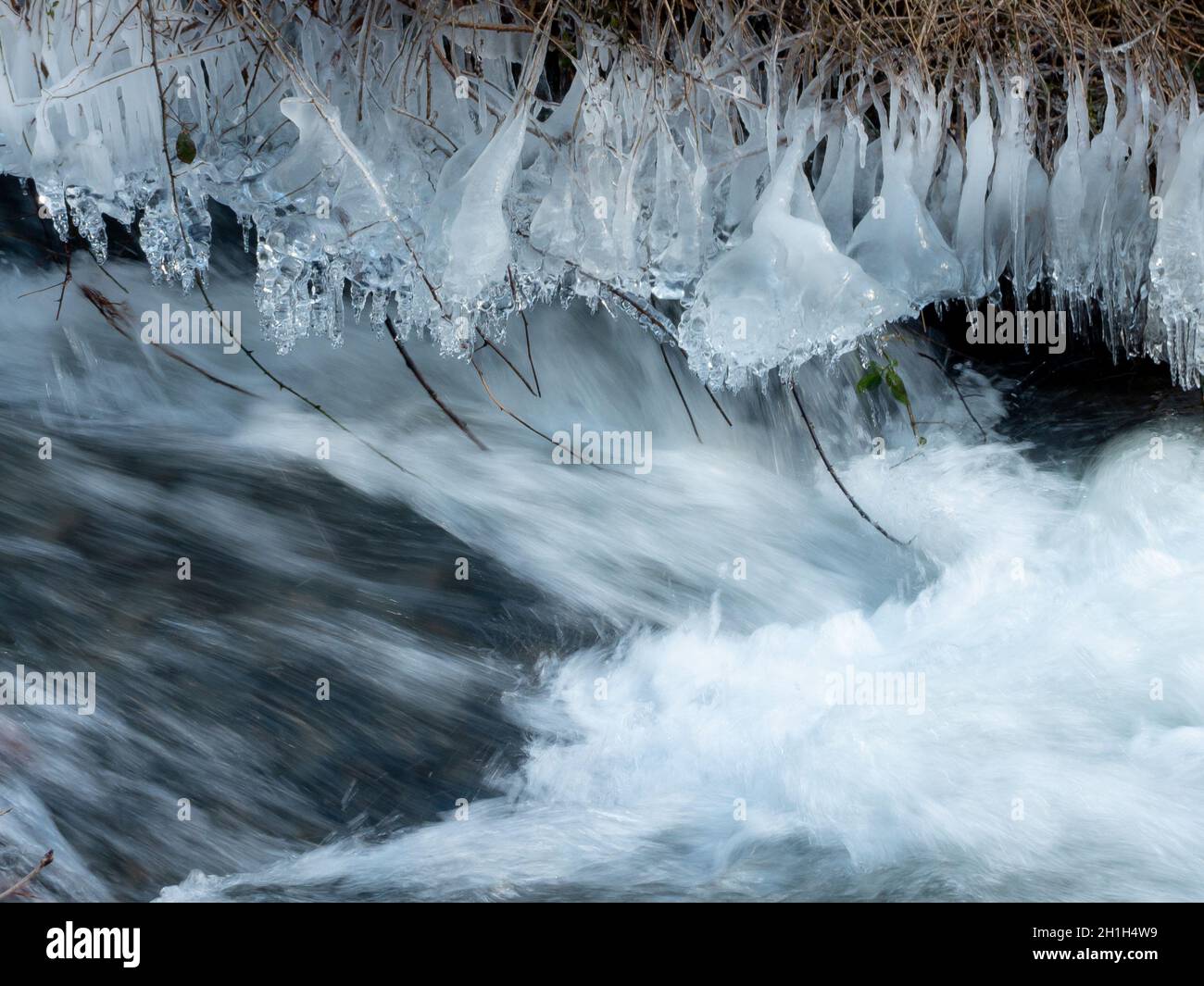 Ice hanging over a creek Stock Photo - Alamy
