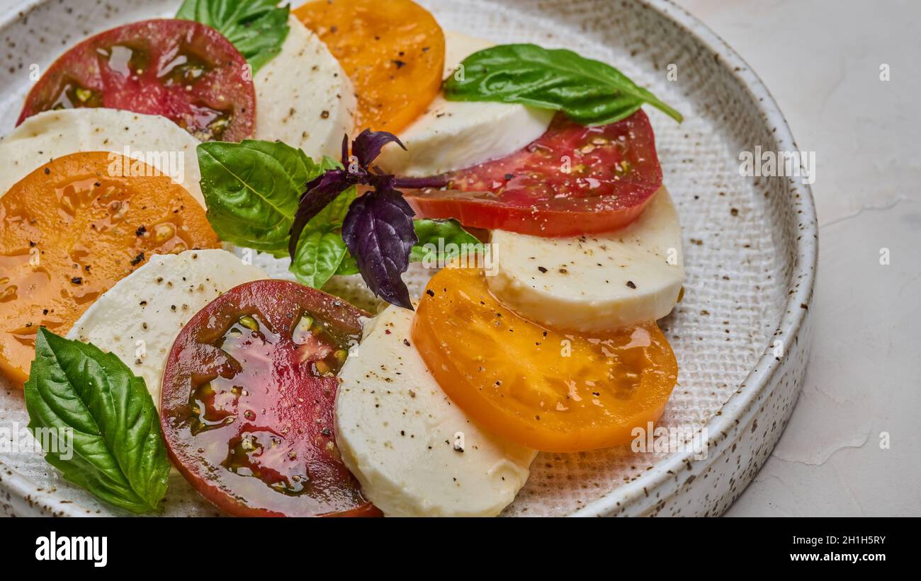 Macro caprese salad with red and yellow tomatoes, fresh basil and ...