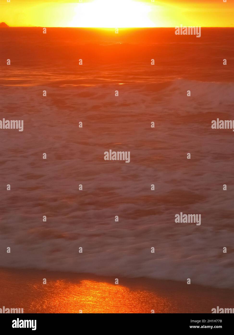 Image of the red sun setting over the ocean Stock Photo - Alamy