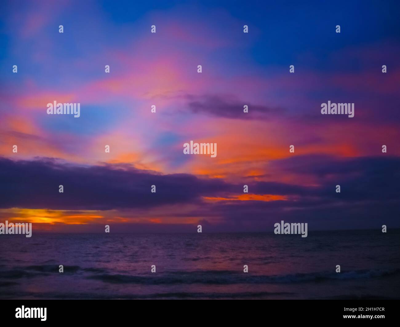 Image of the red sun setting over the ocean Stock Photo - Alamy