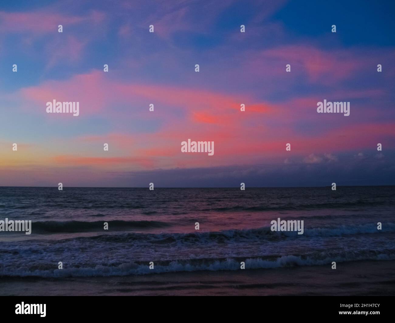 Image of the red sun setting over the ocean Stock Photo - Alamy