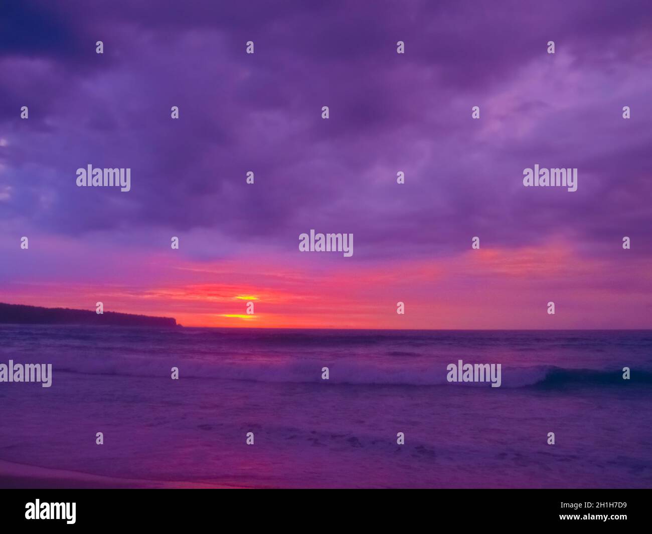 Image of the red sun setting over the ocean Stock Photo - Alamy