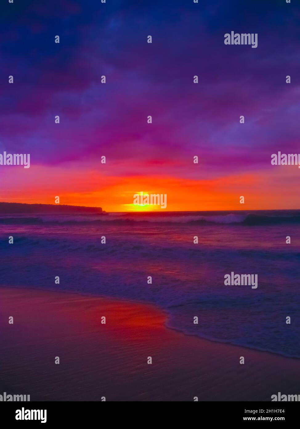 Image of the red sun setting over the ocean Stock Photo - Alamy
