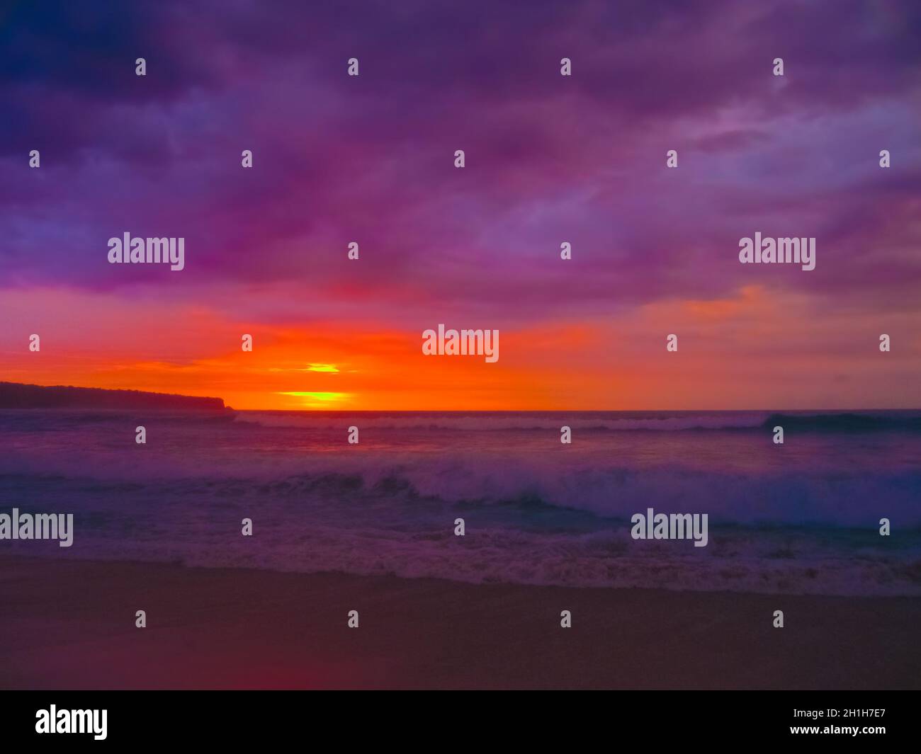 Image of the red sun setting over the ocean Stock Photo - Alamy