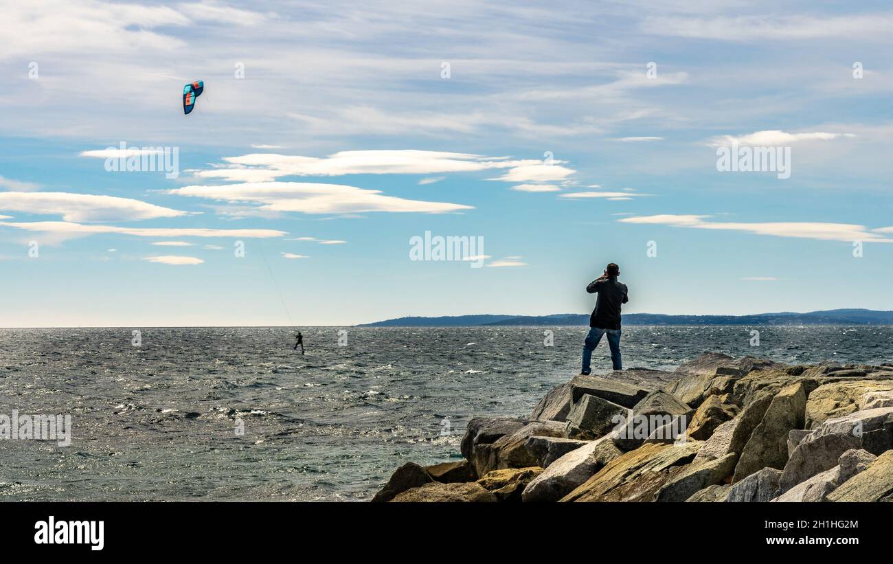 people watching a kite surfer in actionon french riviera in saint ...