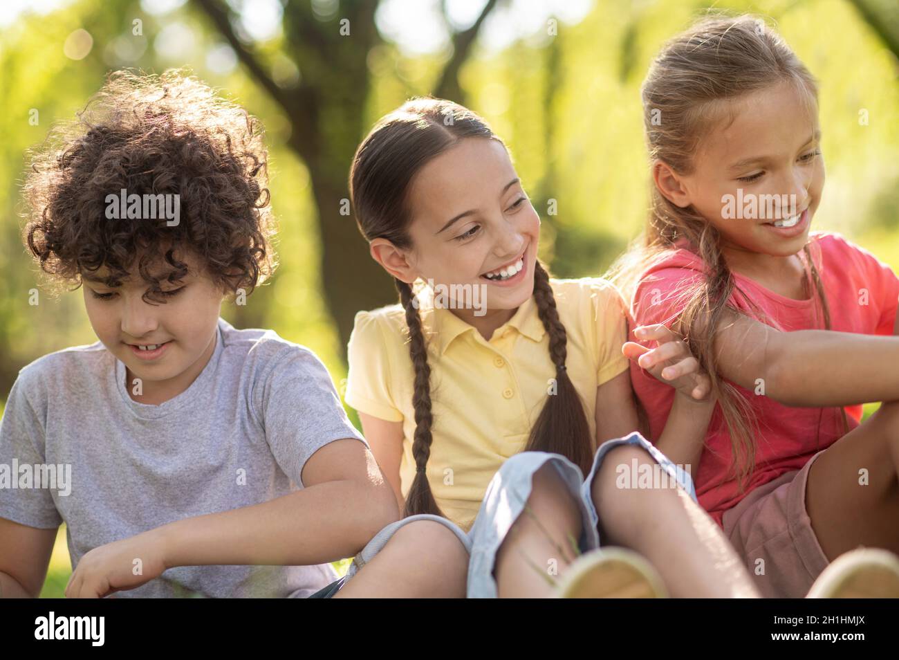 Cheerful two girls and boy in summer park Stock Photo - Alamy