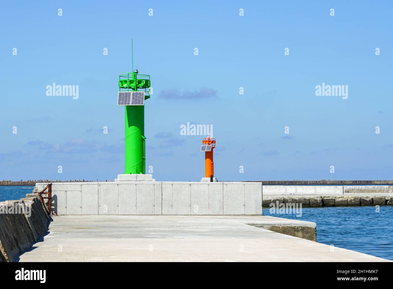 modern harbor breakwaters with navigation towers in red and green and ...