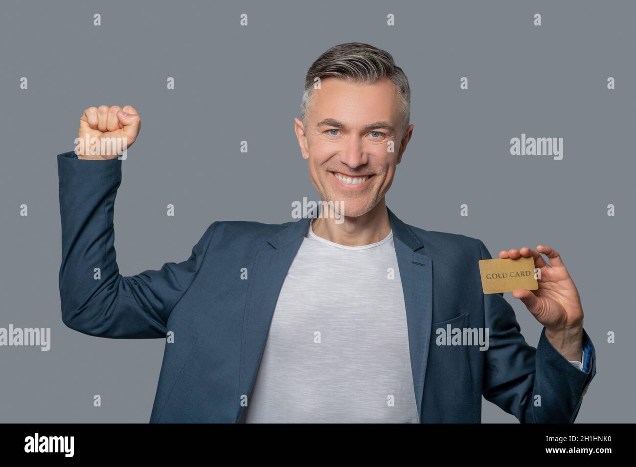Man with credit card raising his hand victoriously Stock Photo - Alamy