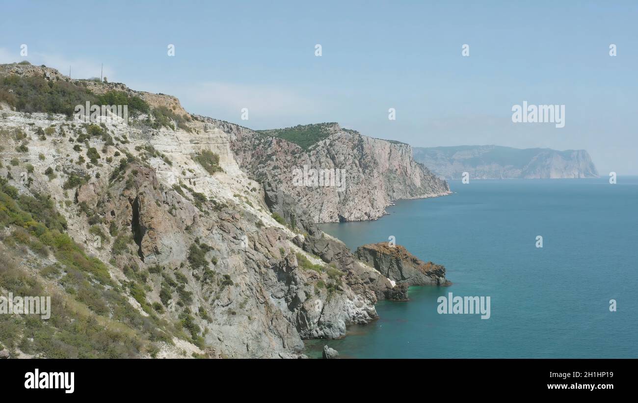 Picturesque coast with rocky cliffs and blue sea. Action. Seascape with ...