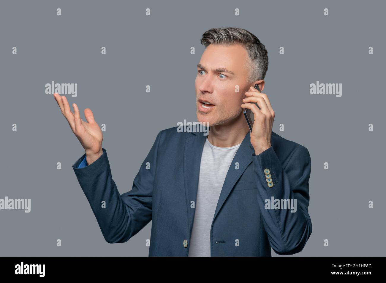 Excited business man talking by smartphone Stock Photo - Alamy