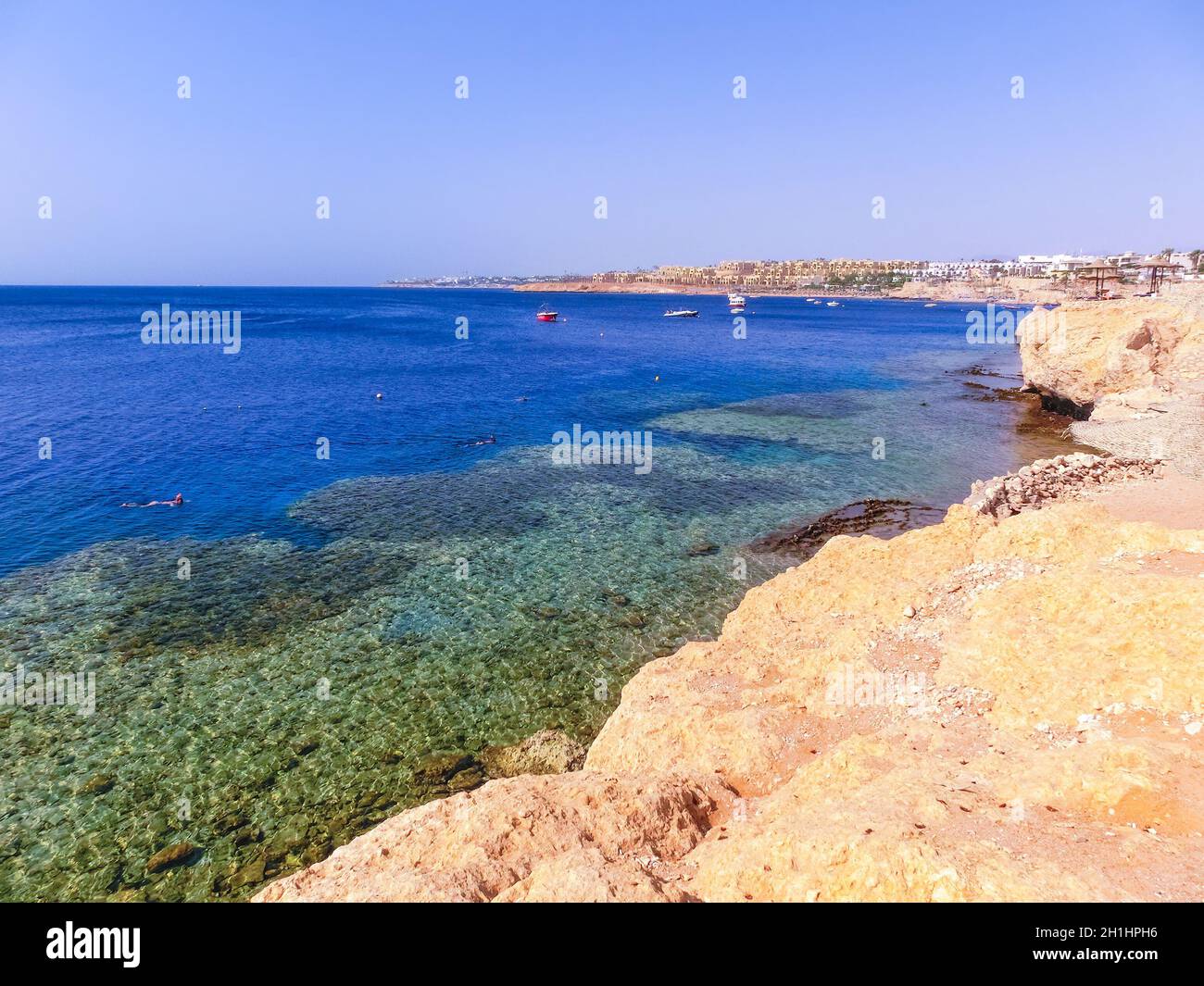 The people snorkeling in blue waters above coral reef on red sea in ...