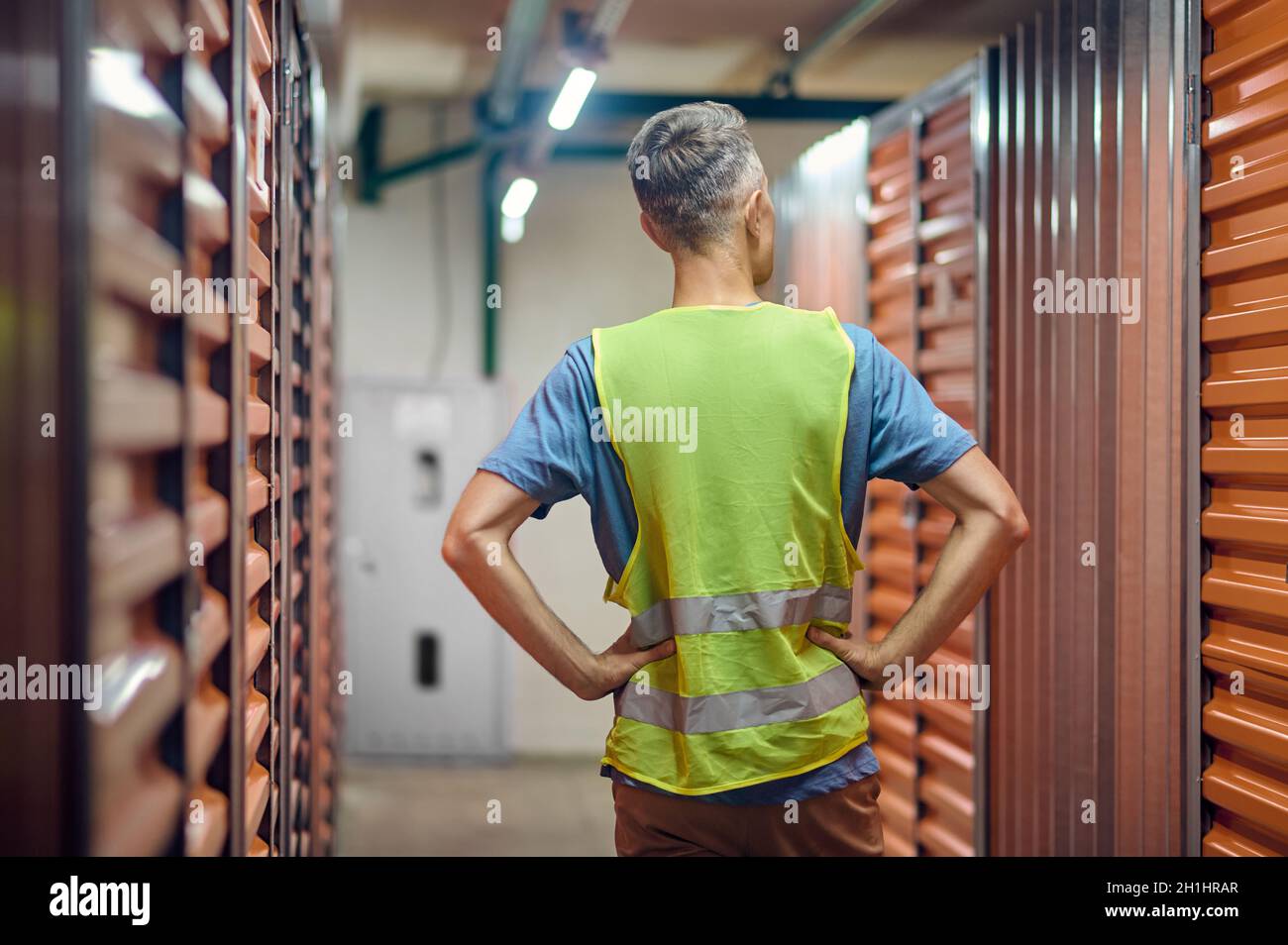 Back view of man standing in warehouse Stock Photo - Alamy