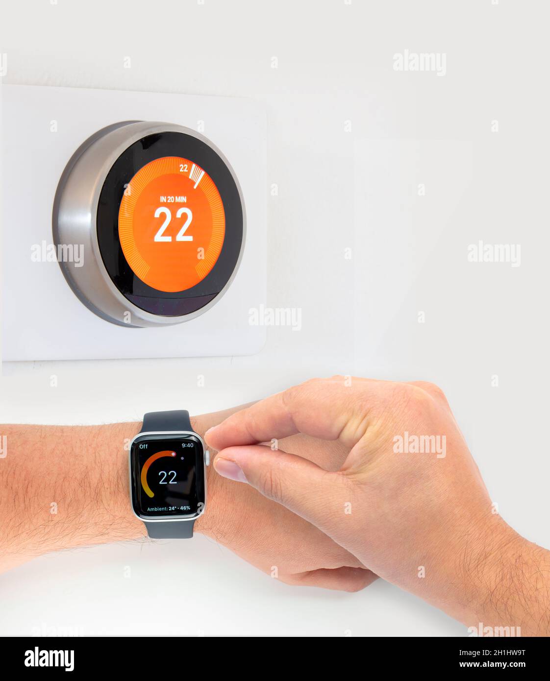 A person controlling a smart thermostat from a smart watch Stock Photo ...