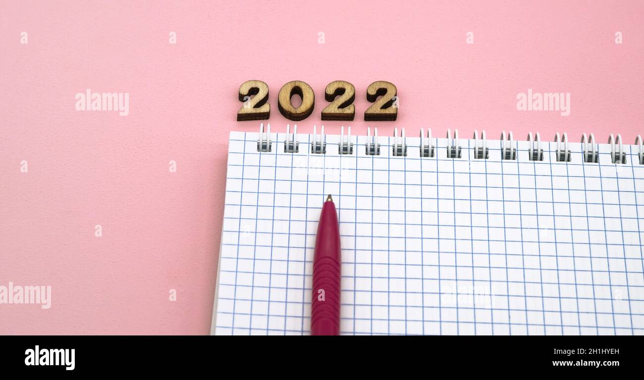 Wooden numbers 2022. Notepad on a spring. Notepad and Pen on Pink. Pink ...