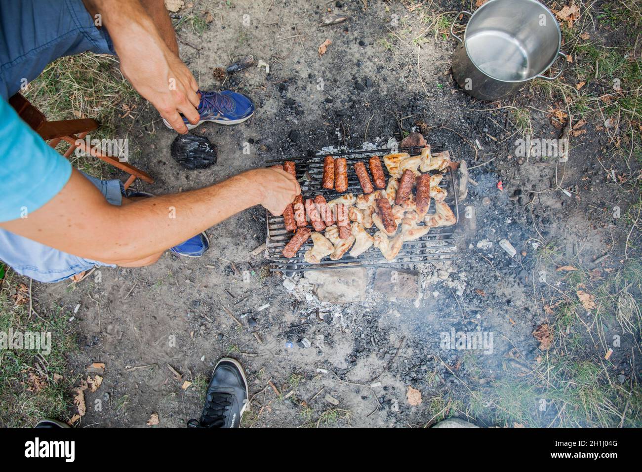 prepares a meat on the barbecue grill, unrecognizable man making ...