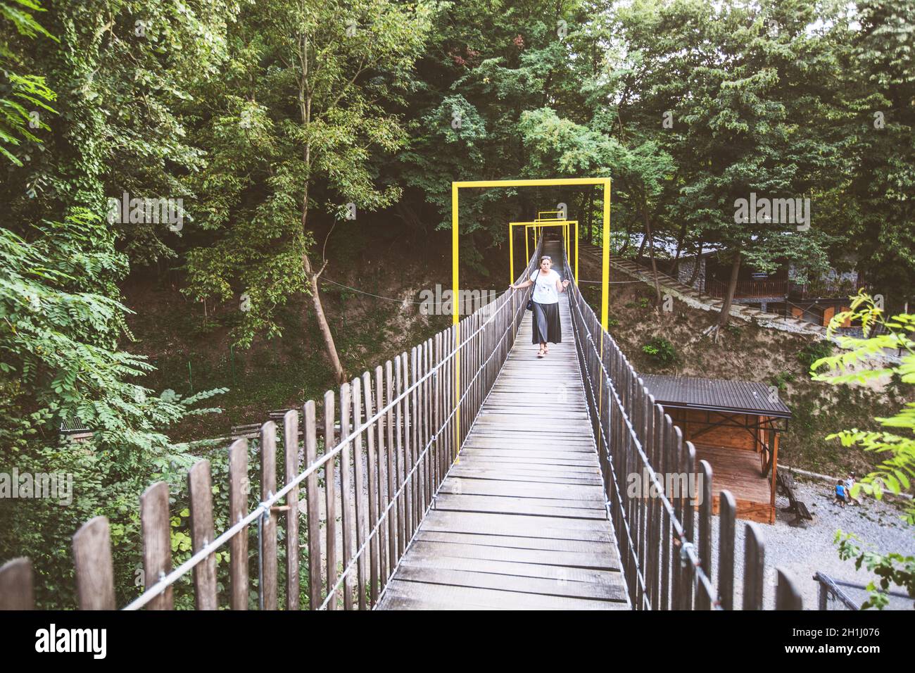 Woman crossing wooden suspension bridge Stock Photo - Alamy