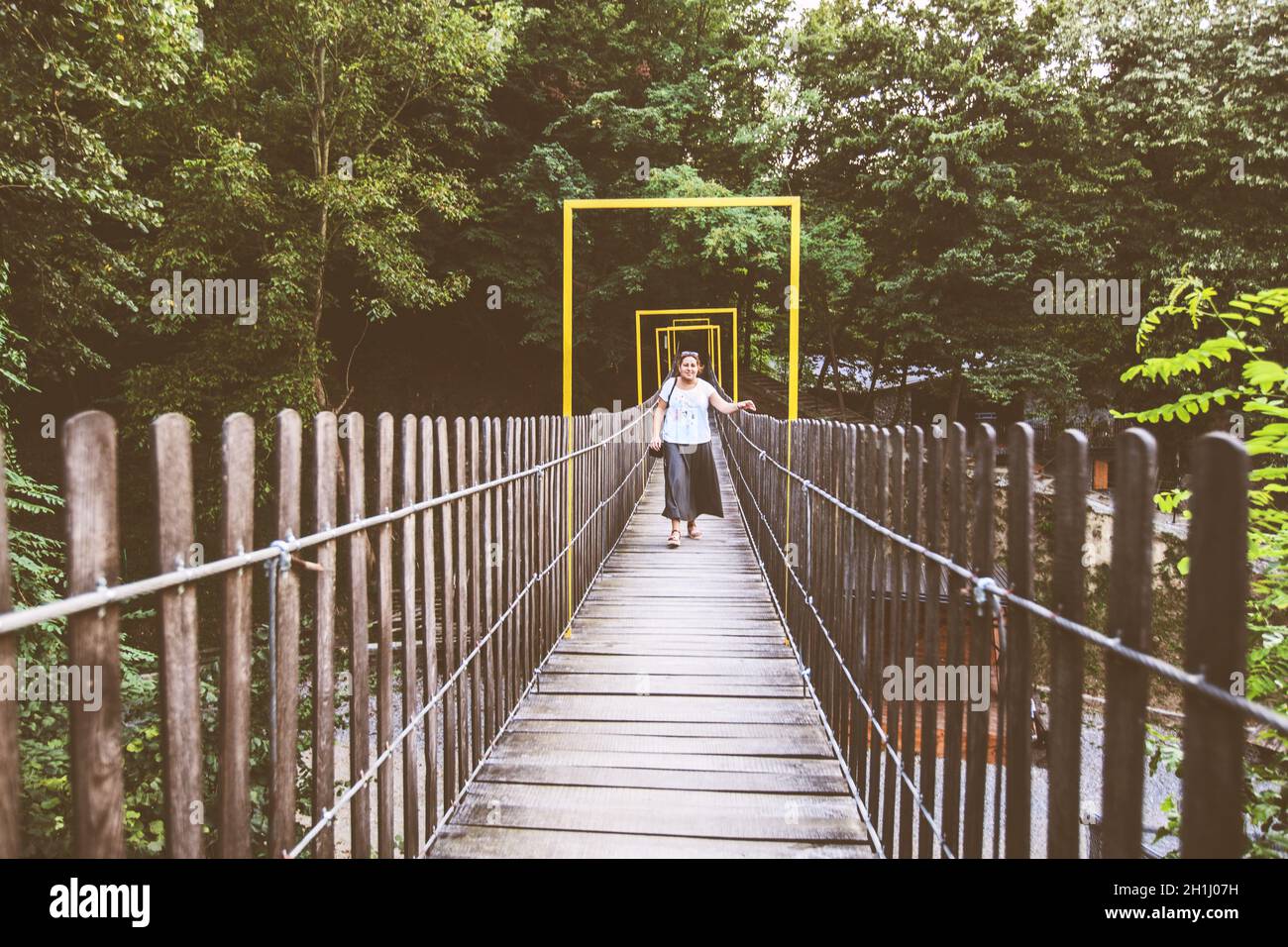Woman crossing wooden suspension bridge Stock Photo - Alamy