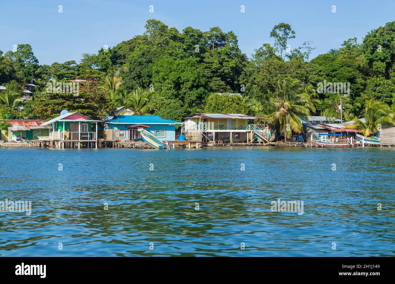 Colorful Caribbean buildings over the water with boats at dock, Bocas ...