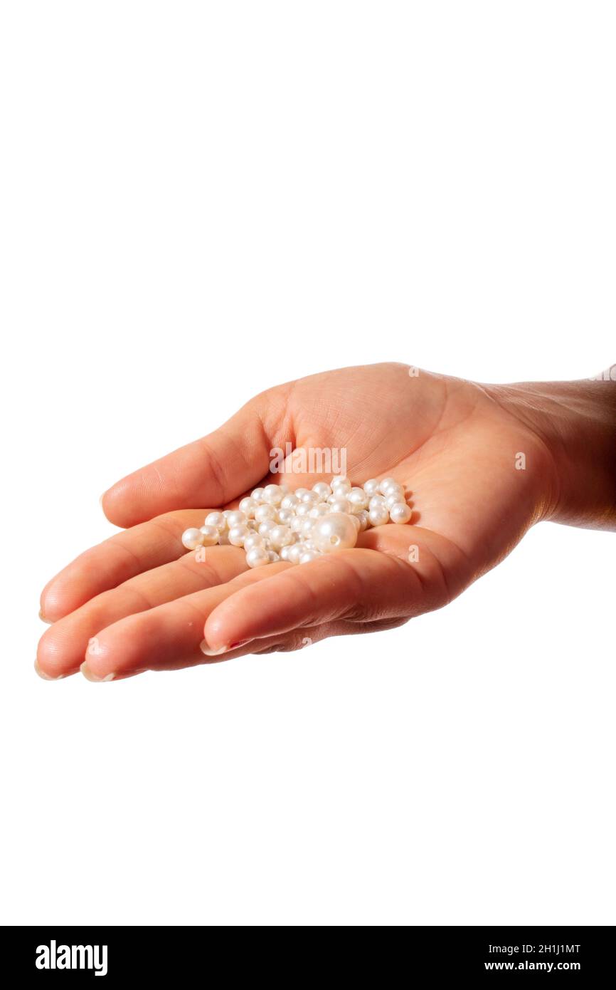 Woman's hand with a handful of white pearls for necklace. Isolated on ...