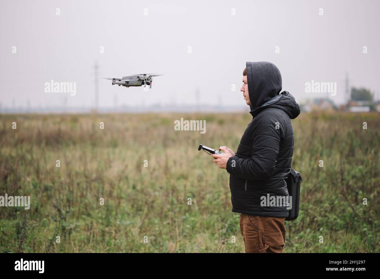 Portrait of drone operator flying aircraft quadcopter near the forest ...