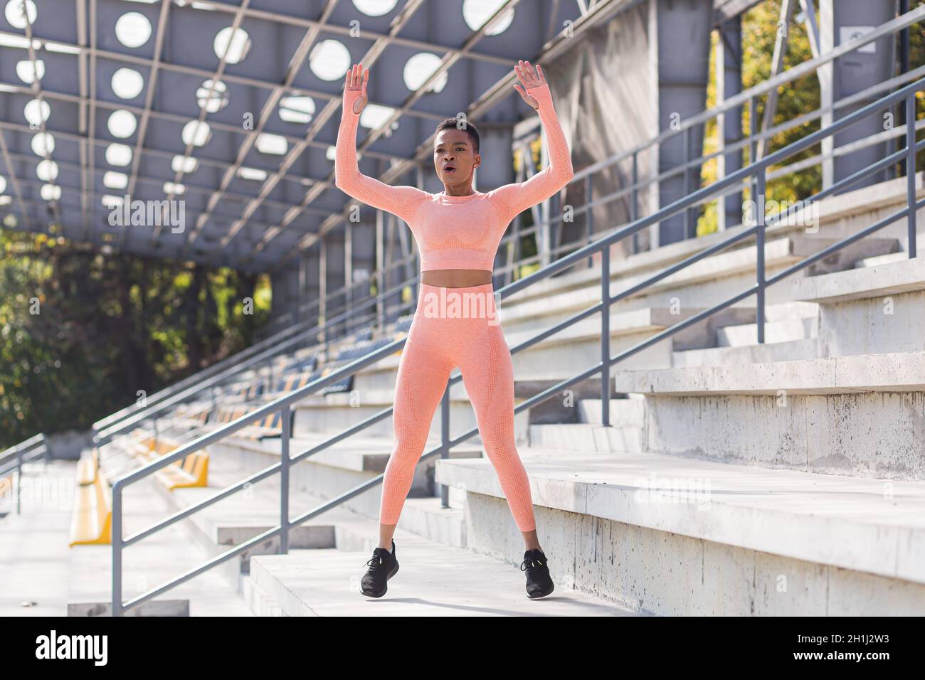 Woman doing burpee exercise, young African American woman doing fitness ...