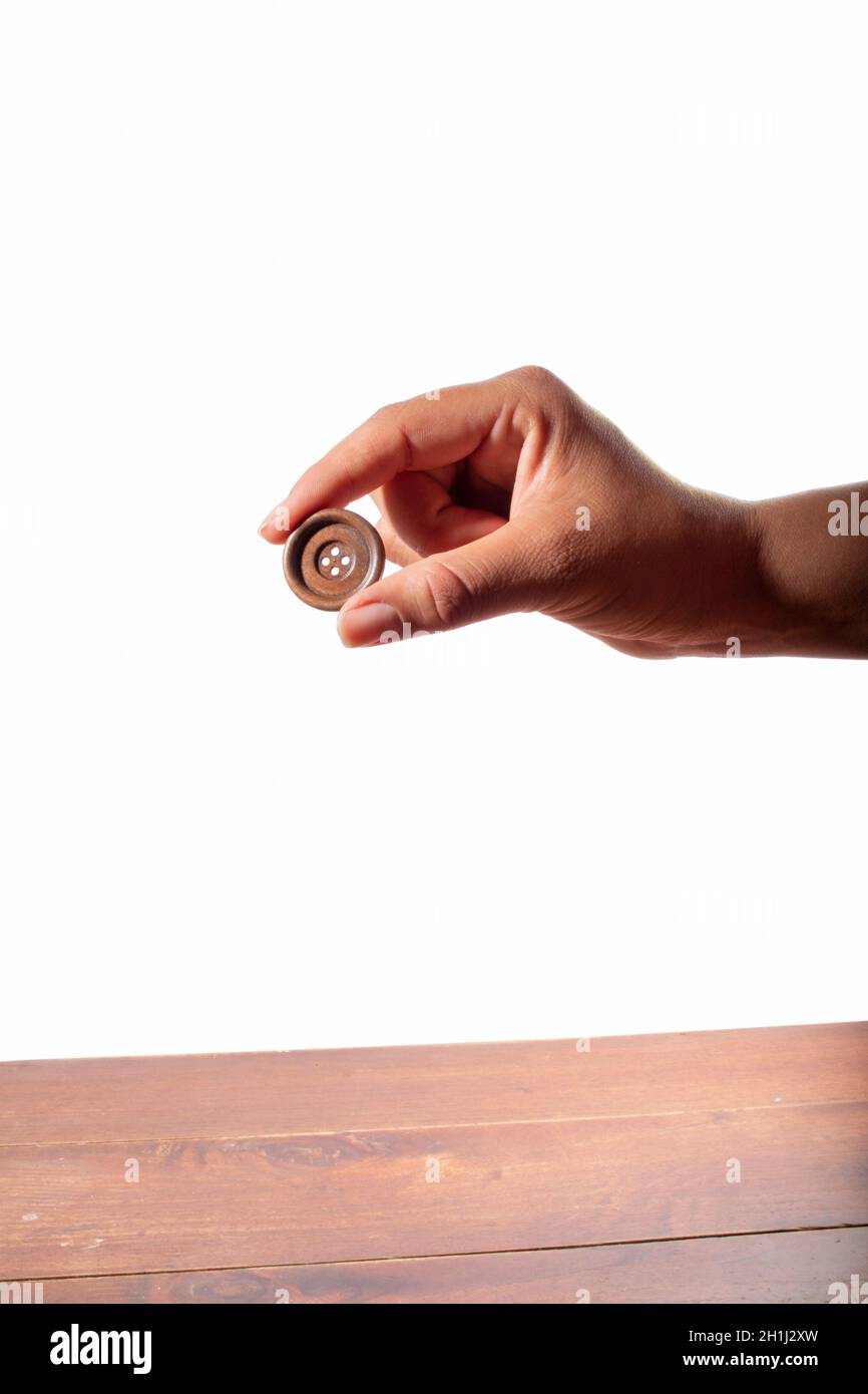 Hand holding a clothing button. Hand isolated on white background Stock ...