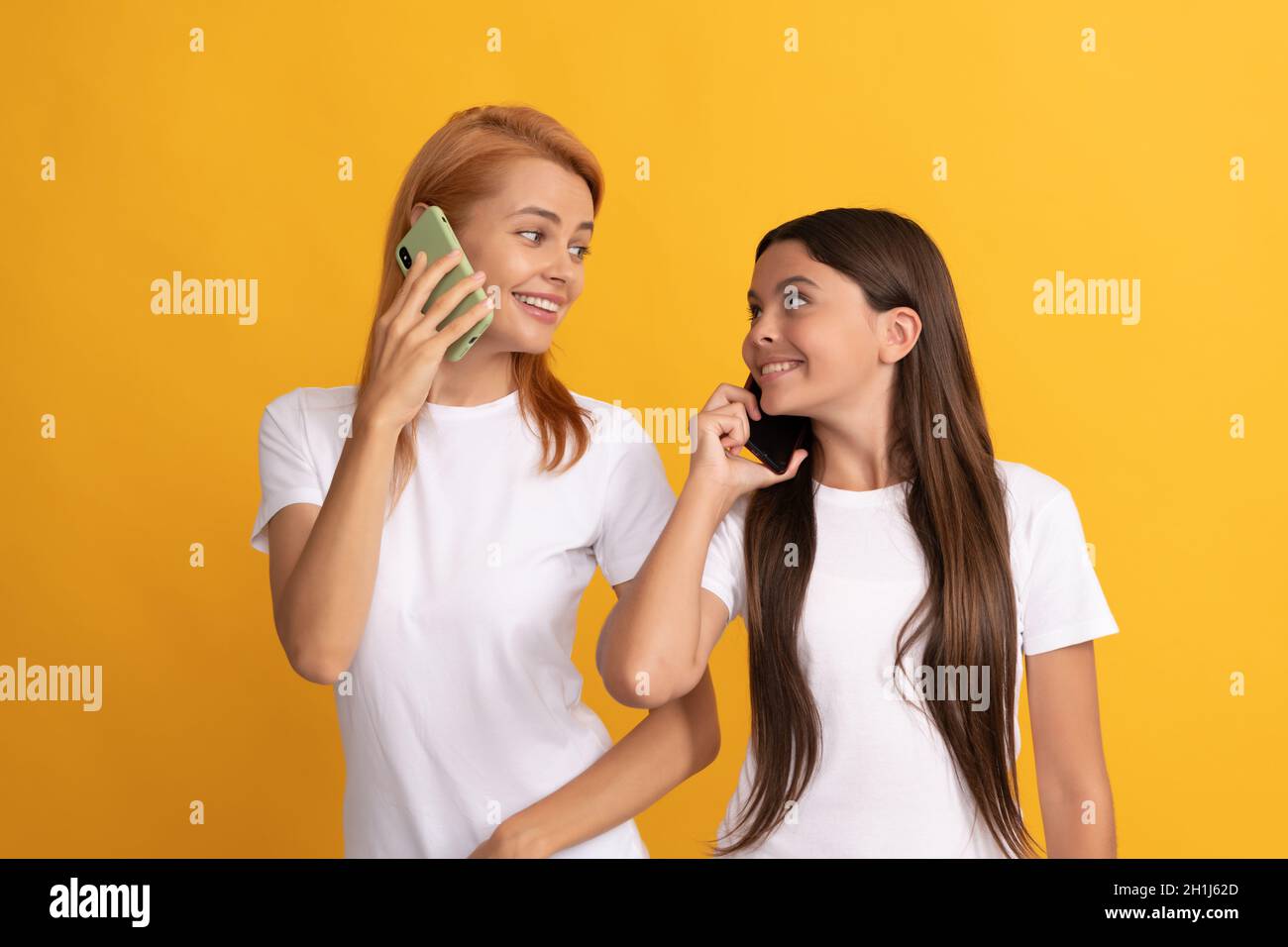 voice contact. happy woman and girl talk on smartphone. family ...