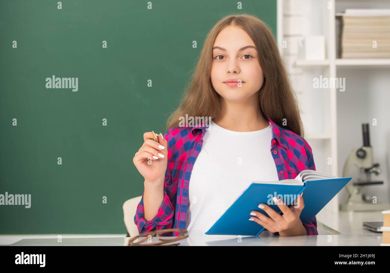 smiling child making notes in notebook. back to school. teen girl ready ...