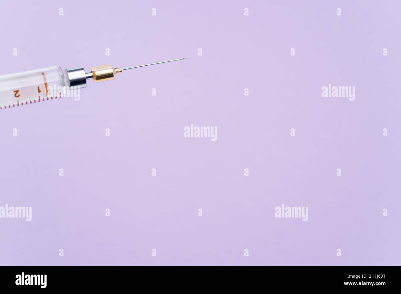 isolated sterilized glass injection syringe on a lilac paper background ...
